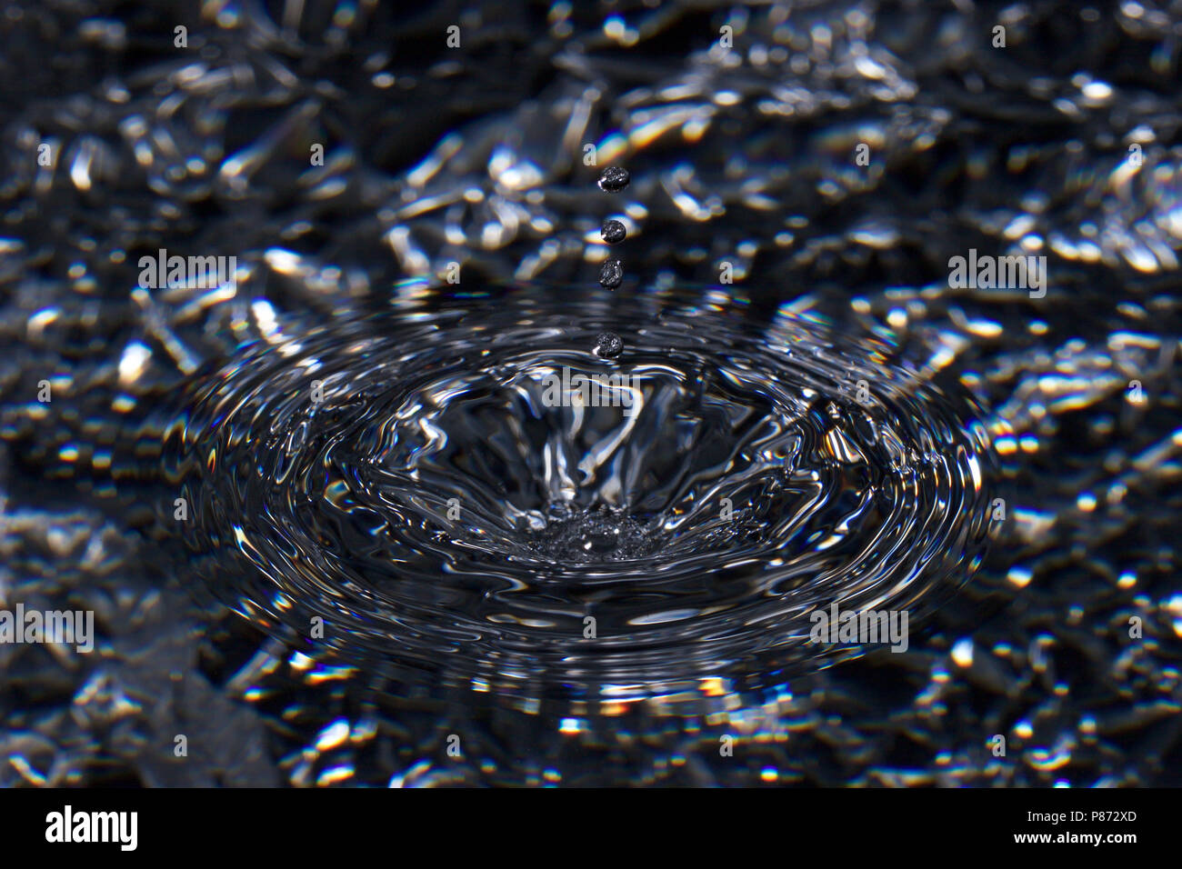 Water droplets falling into water causing splashes and ripples Stock ...