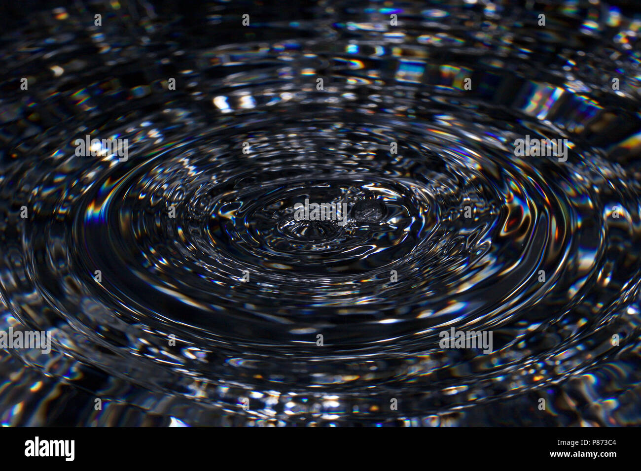 Water droplets falling into water causing splashes and ripples Stock ...