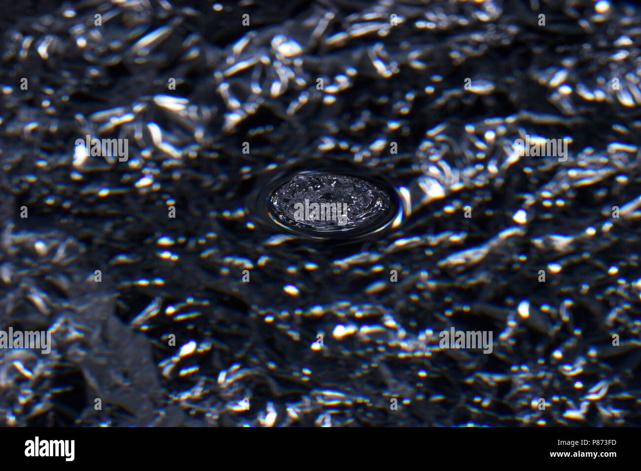 Water droplets falling into water causing splashes and ripples Stock ...