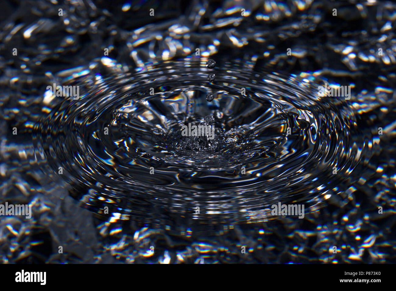 Water droplets falling into water causing splashes and ripples Stock ...