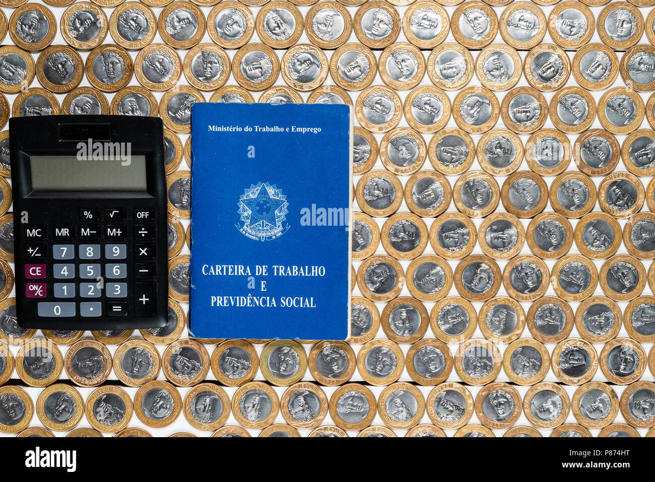 Work permit and black calculator on several Brazilian one real coins ...