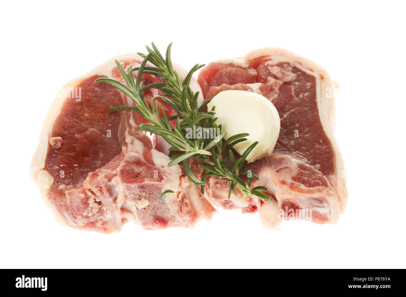 Two raw lamb chops with rosemary and garlic isolated against white ...