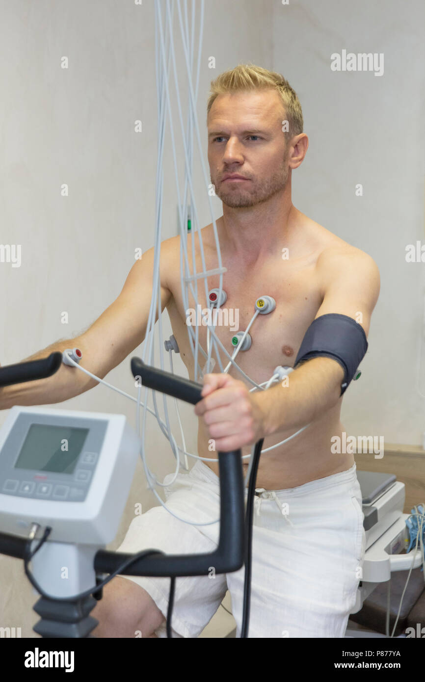 doctor with electrocardiogram equipment making cardiogram bike test to ...