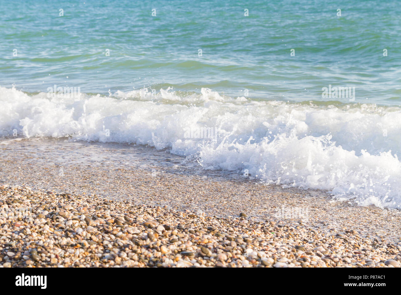A wave of the sea running on a sandy and pebble beach Stock Photo - Alamy