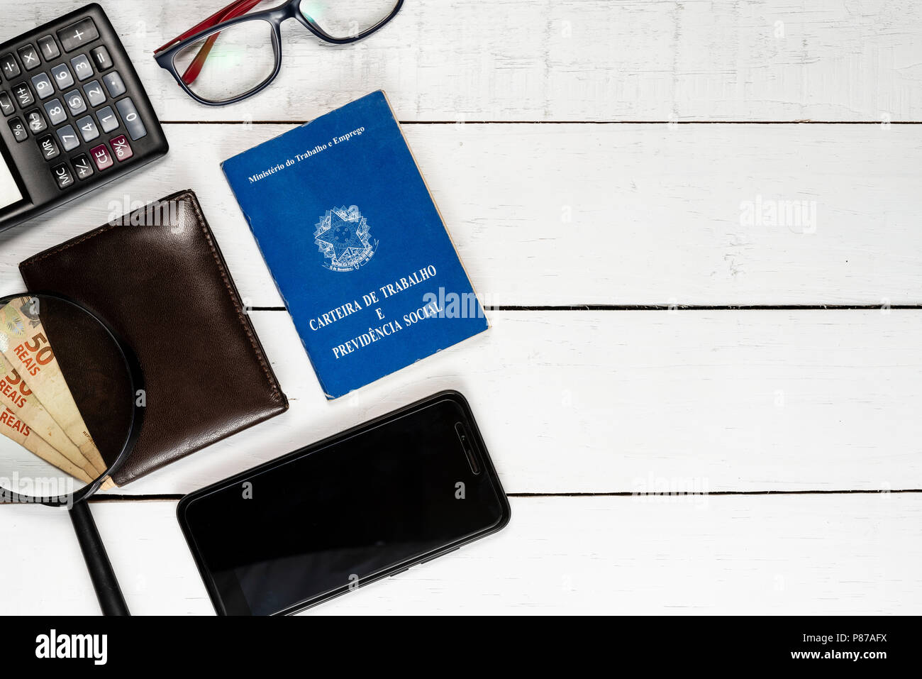 Wallet with Brazilian money notes, glasses, glasses, calculator and ...