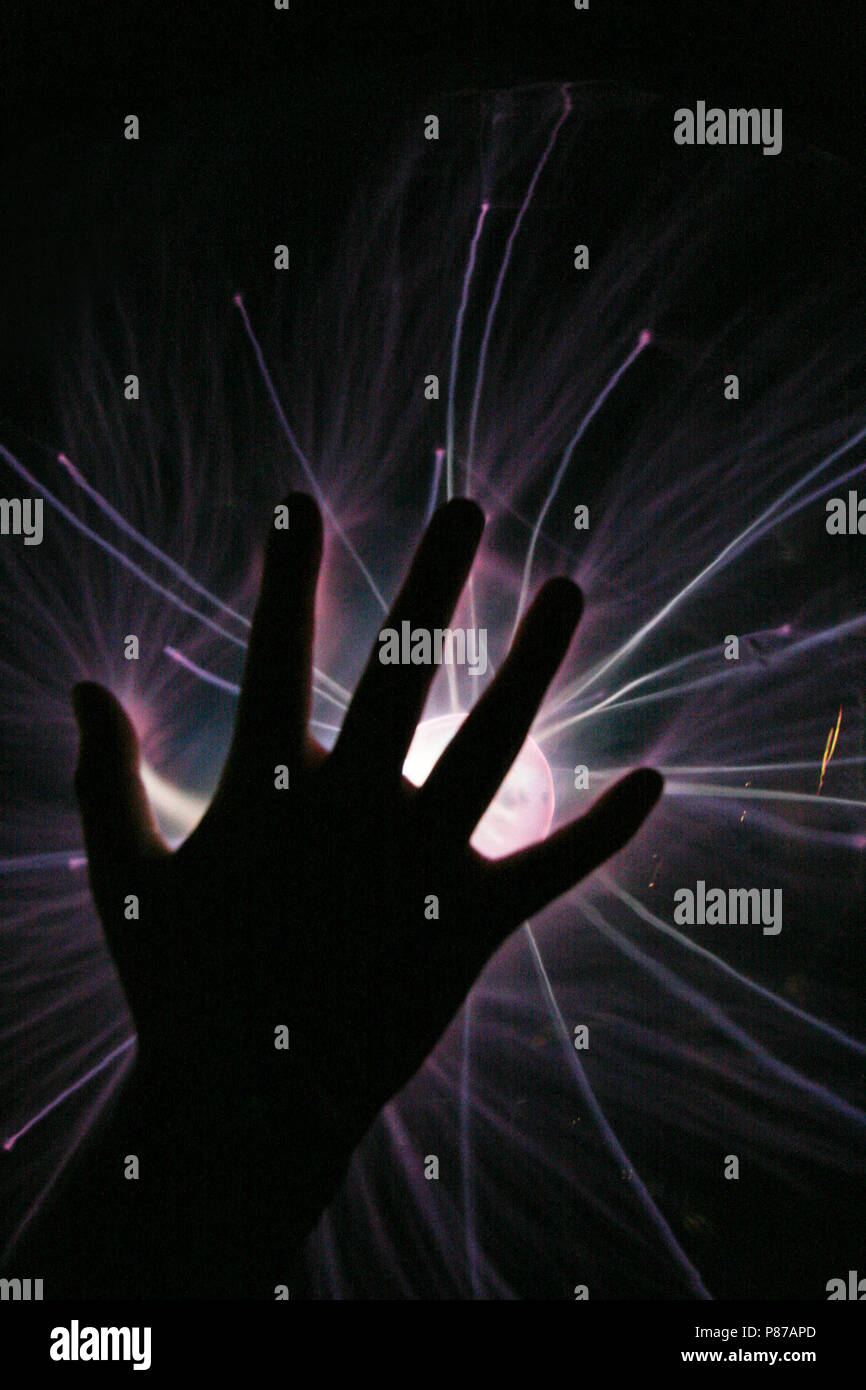 Hand on plasma lamp looks like bolt of electricity charging from hand ...