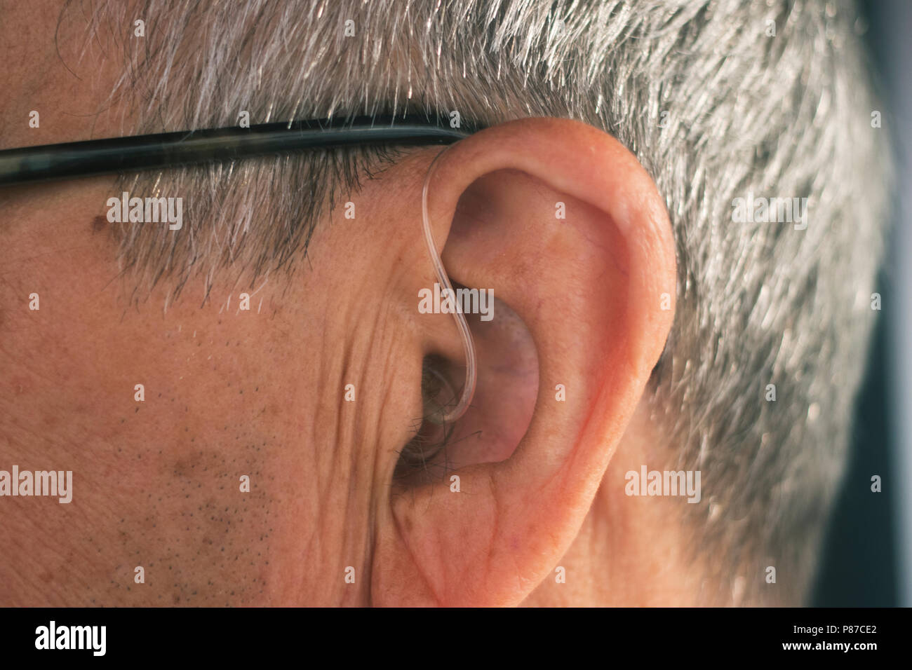 Deaf senior citizen man wearing modern digital high technology hearing ...