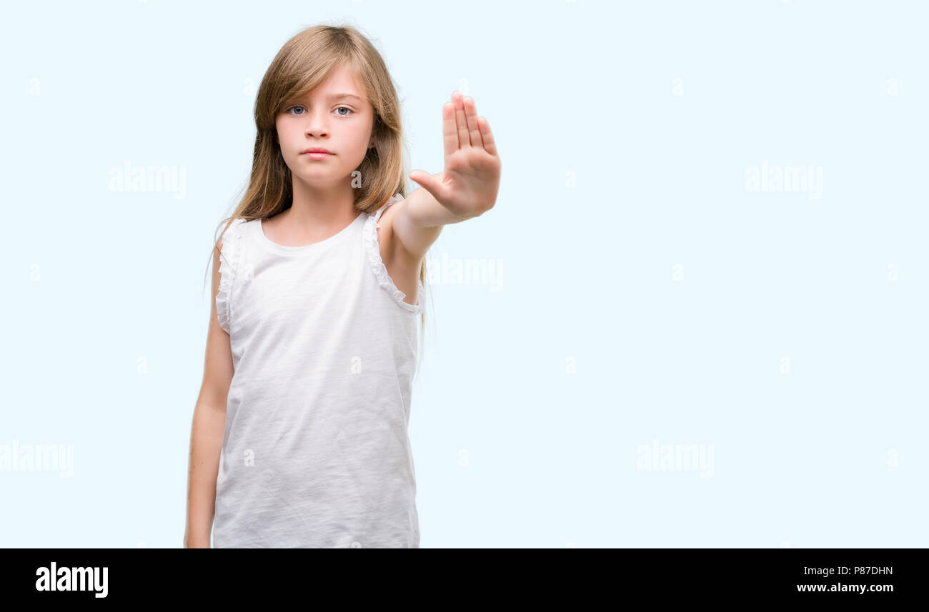 Young blonde toddler with open hand doing stop sign with serious and ...