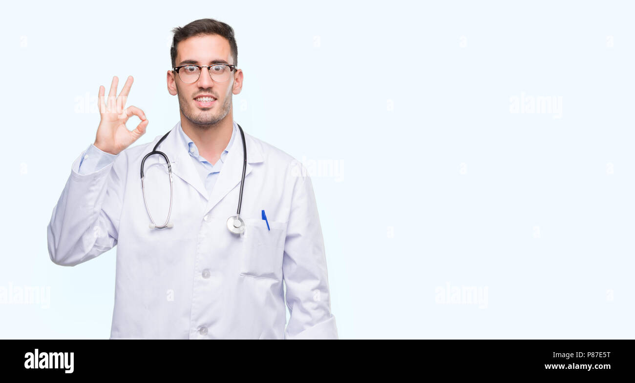Handsome young doctor man smiling positive doing ok sign with hand and ...
