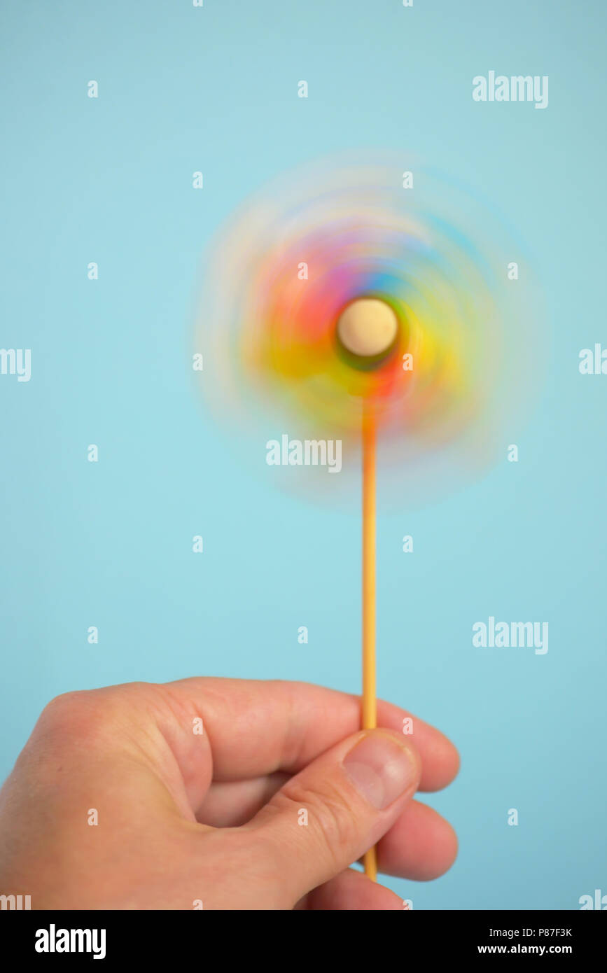 Toy Multi-colored windmill and hand Stock Photo - Alamy
