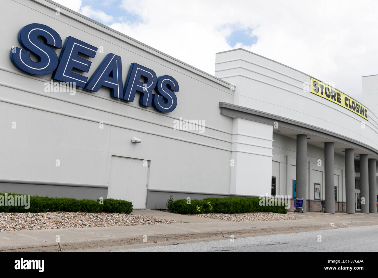 A logo sign and 'Store Closing' banner outside of a Sears retail store ...