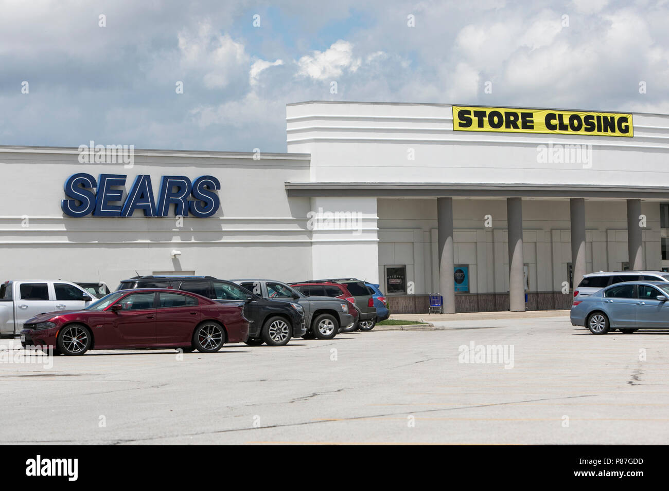 A logo sign and 'Store Closing' banner outside of a Sears retail store ...