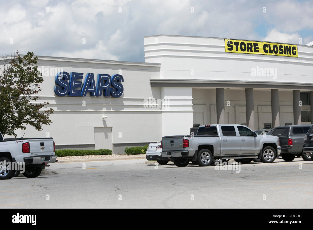 A logo sign and 'Store Closing' banner outside of a Sears retail store ...