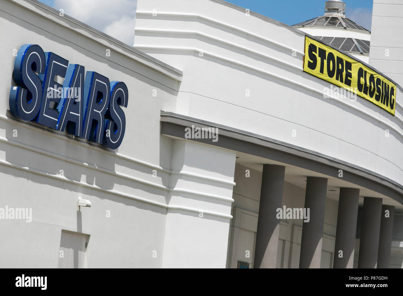A logo sign and 'Store Closing' banner outside of a Sears retail store ...