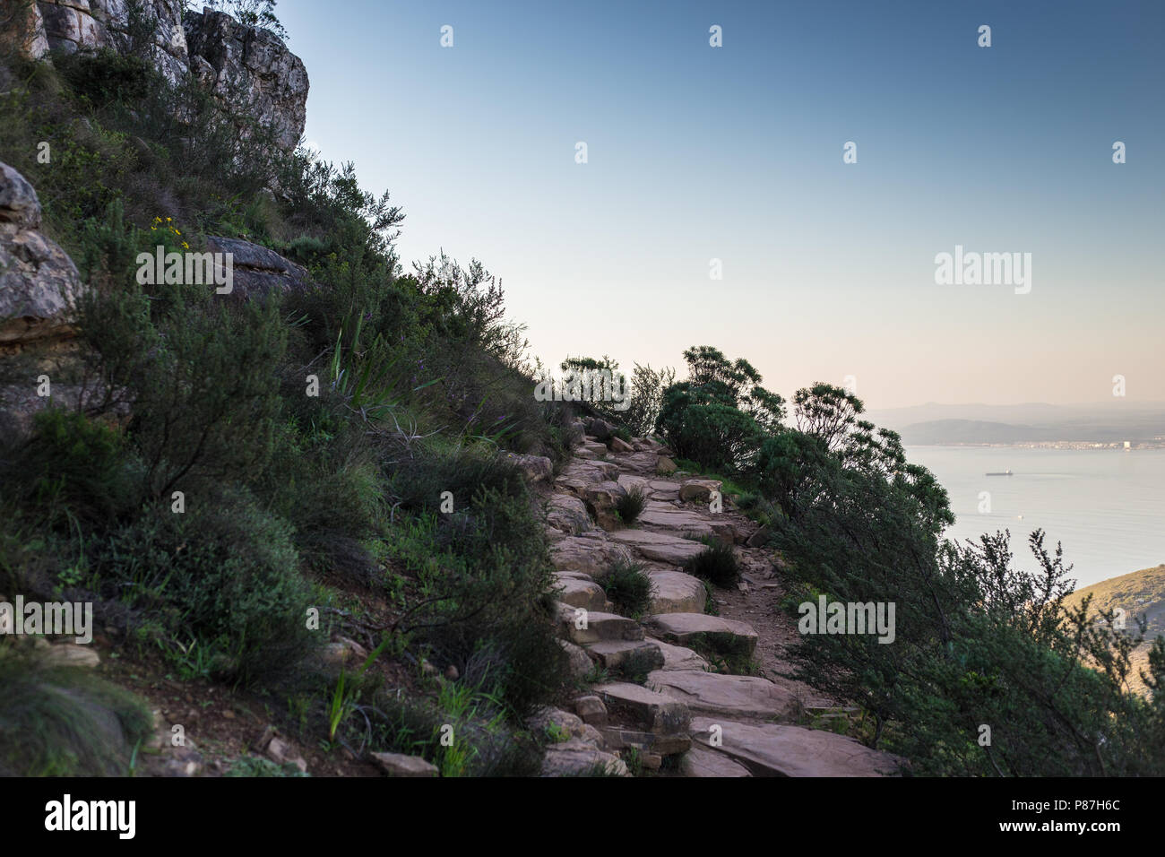 Rocky pathway along a mountain with blue sky horizon Stock Photo - Alamy