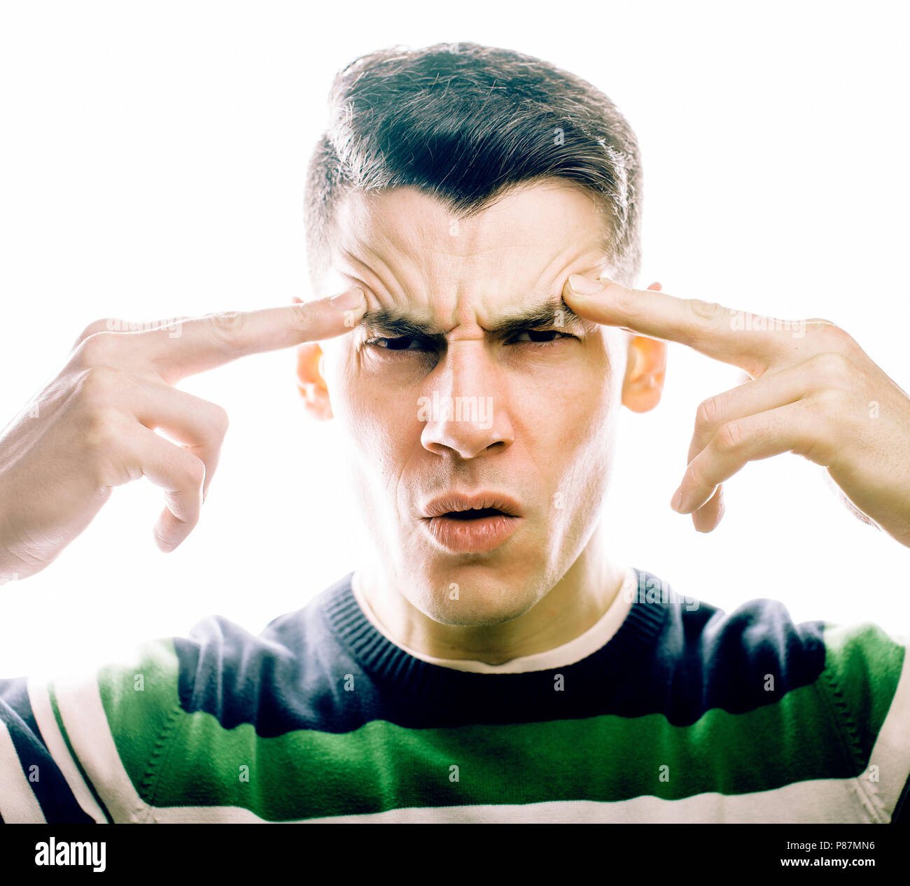 Portrait of a smart serious young man standing against white bac Stock ...