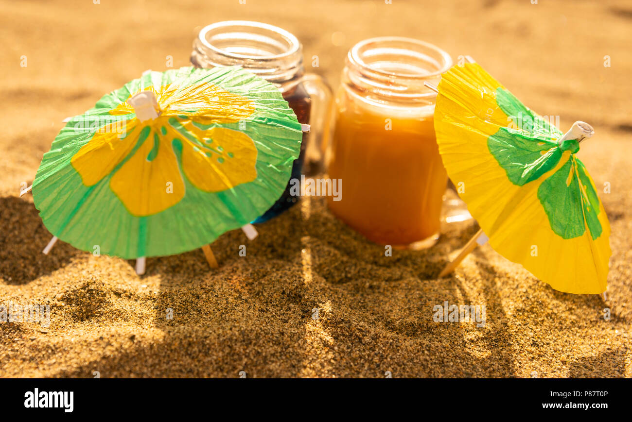 colorful shots drinks on a sandy beach with umbrellas for drinks ...