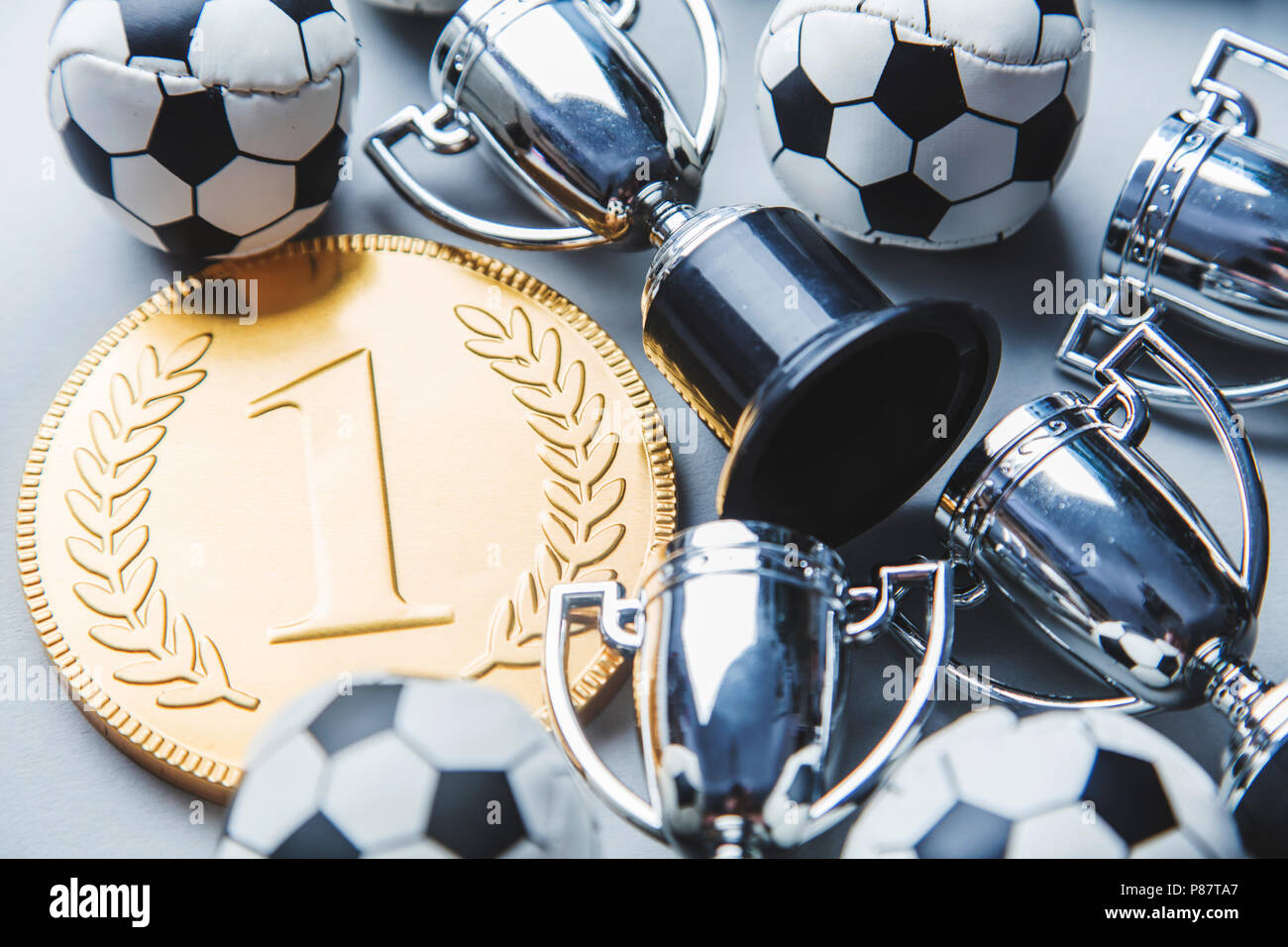 Gold first place winners medal and trophy with a soccer ball. Football ...