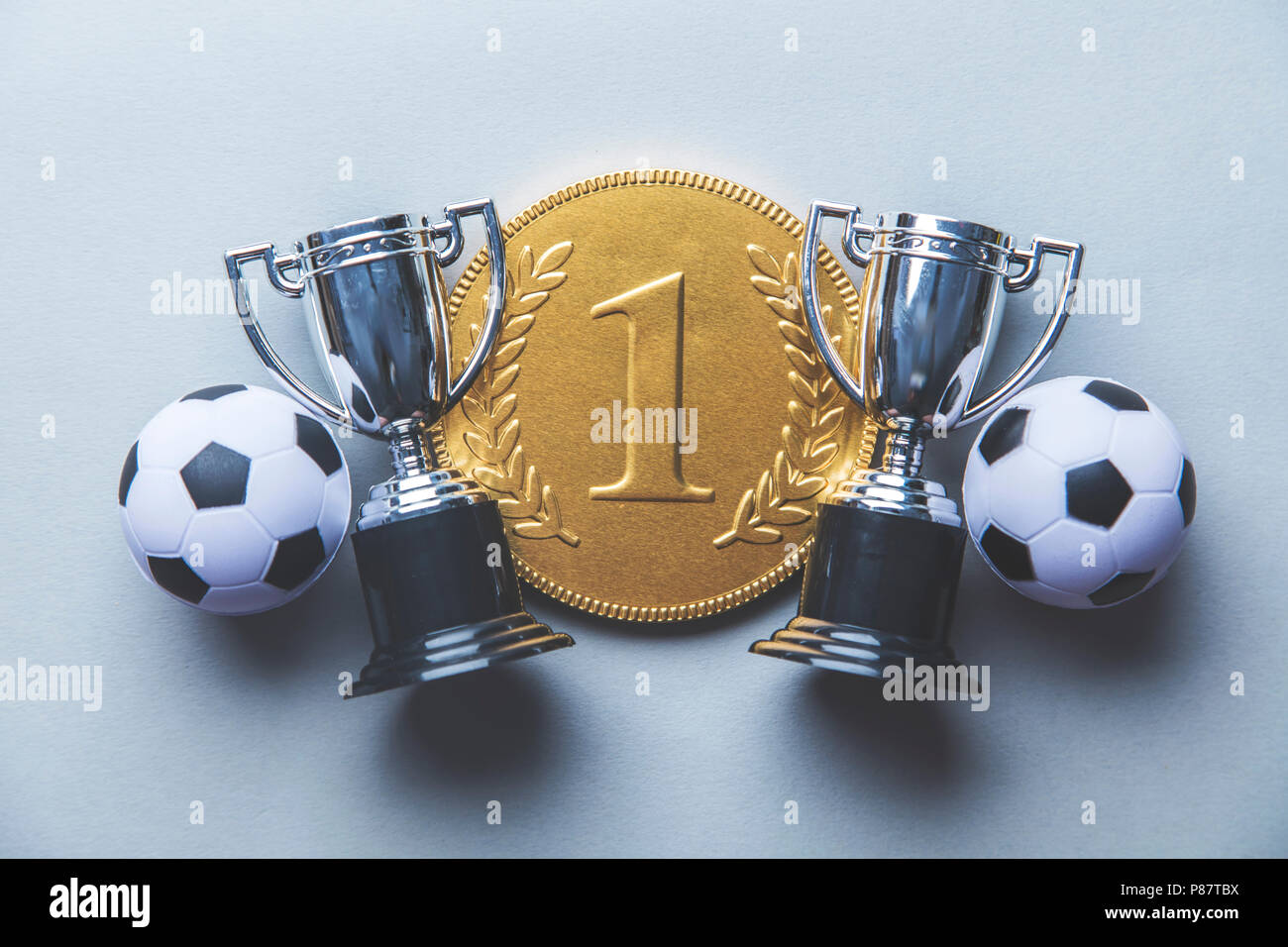 Gold first place winners medal and trophy with a soccer ball. Football ...