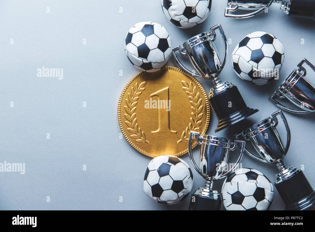 Gold first place winners medal and trophy with a soccer ball. Football ...