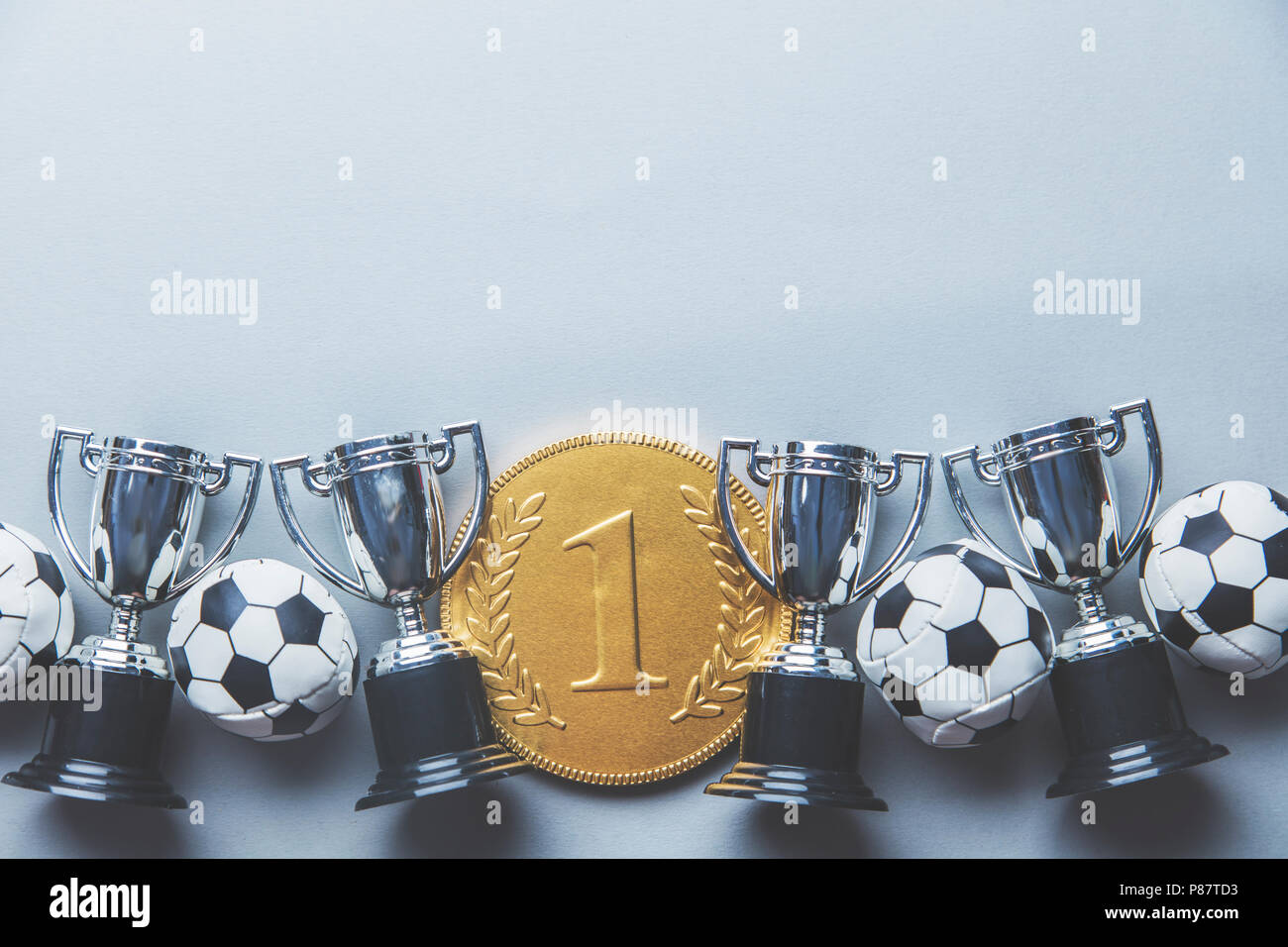 Gold first place winners medal and trophy with a soccer ball. Football ...
