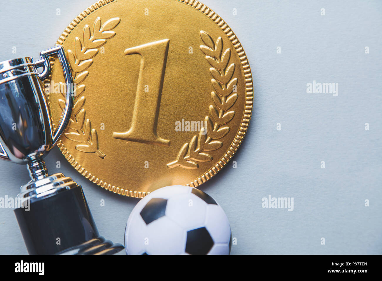 Gold first place winners medal and trophy with a soccer ball. Football ...