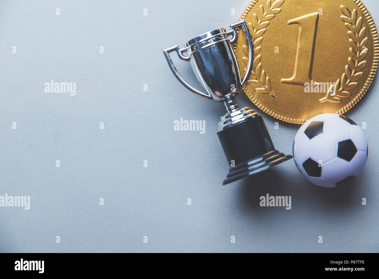 Gold first place winners medal and trophy with a soccer ball. Football ...