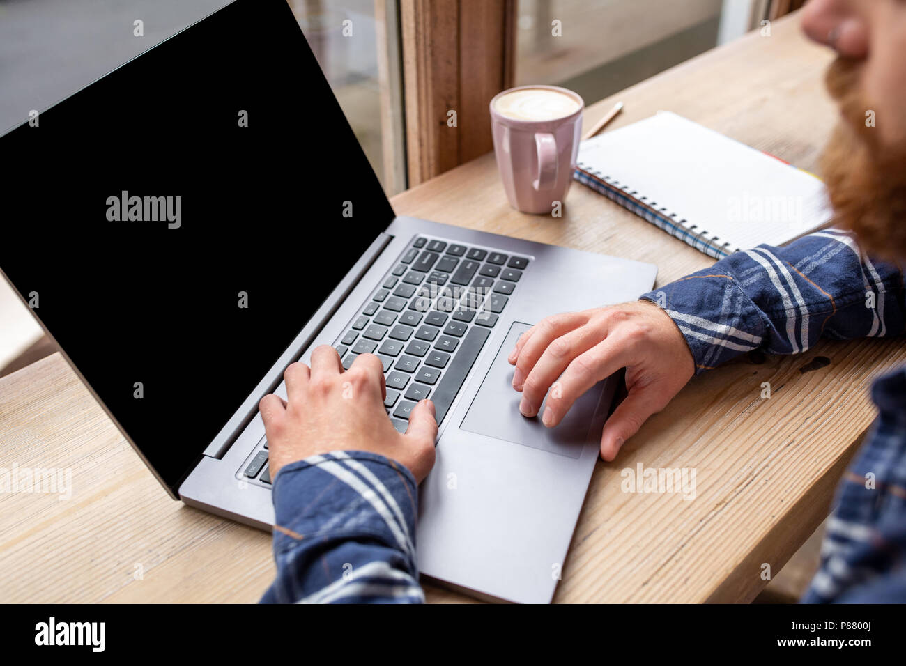 Cropped image of young man chatting via net-book during work break in ...