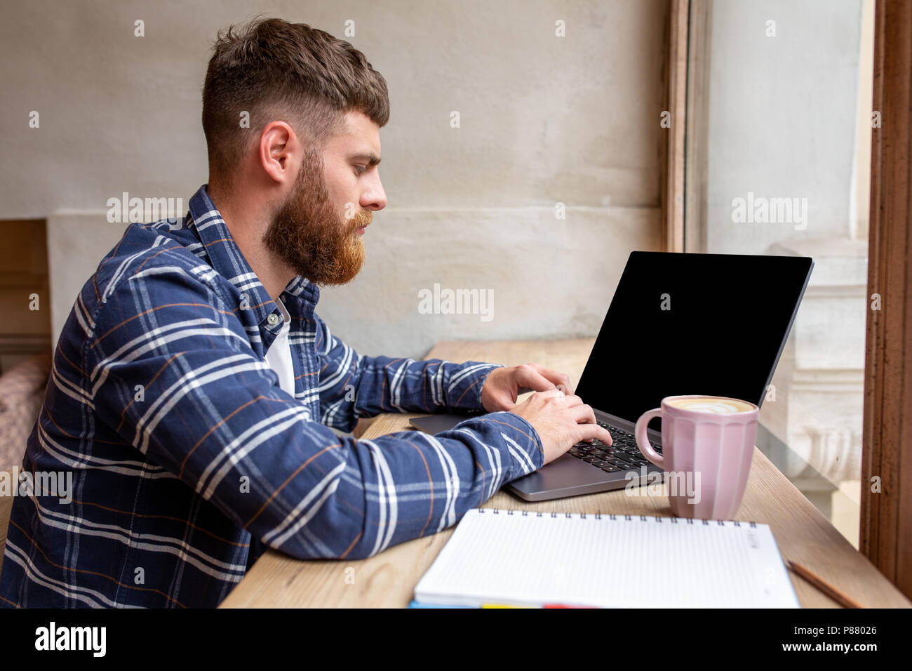 Young man chatting via net-book during work break in coffee shop, male ...