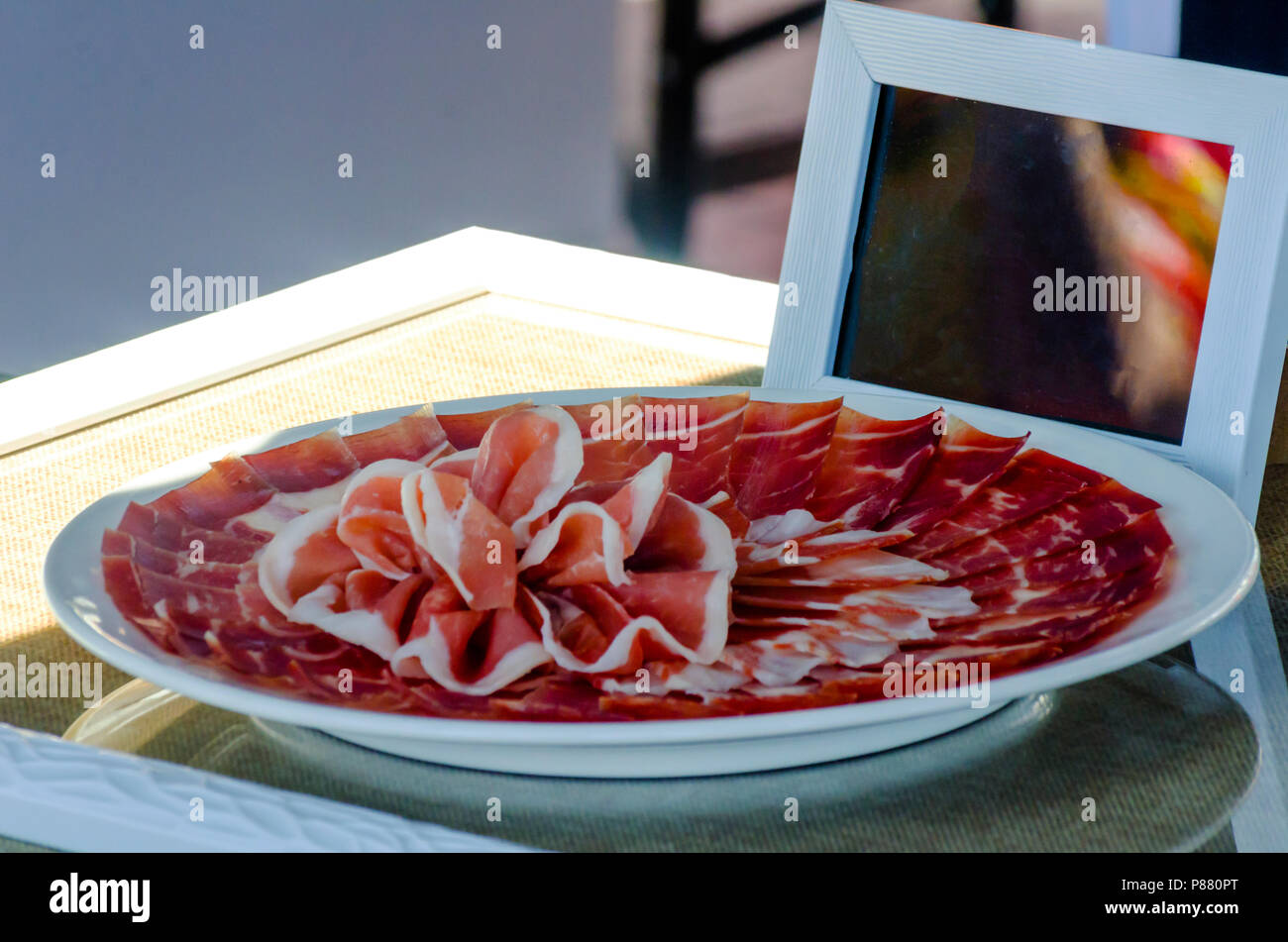 plate with cut slices of jamon serrano, traditional Spanish ham, meat ...