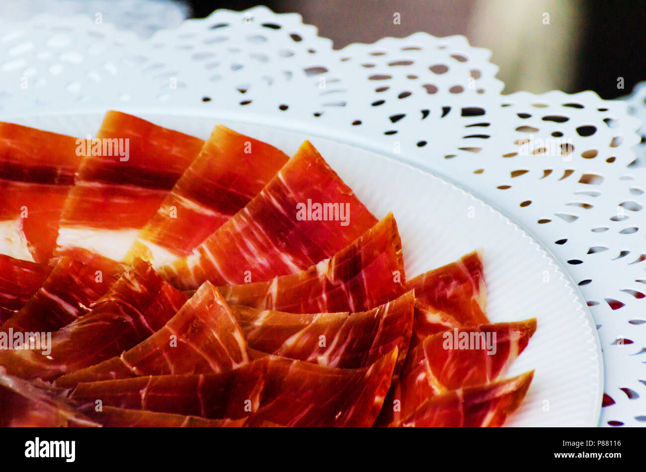 plate with cut slices of jamon serrano, traditional Spanish ham, meat ...