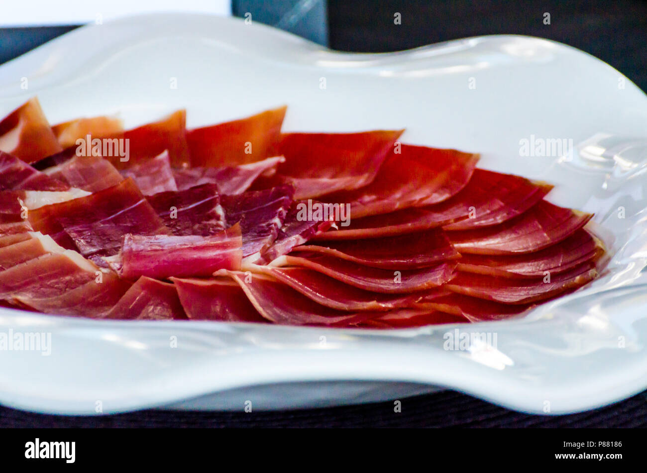 plate with cut slices of jamon serrano, traditional Spanish ham, meat ...