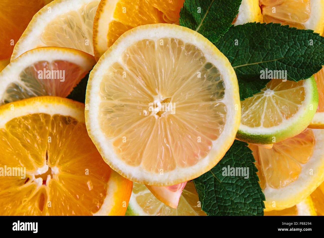 Citrus background. Many slices of lemon, orange, lime and mint leaves ...