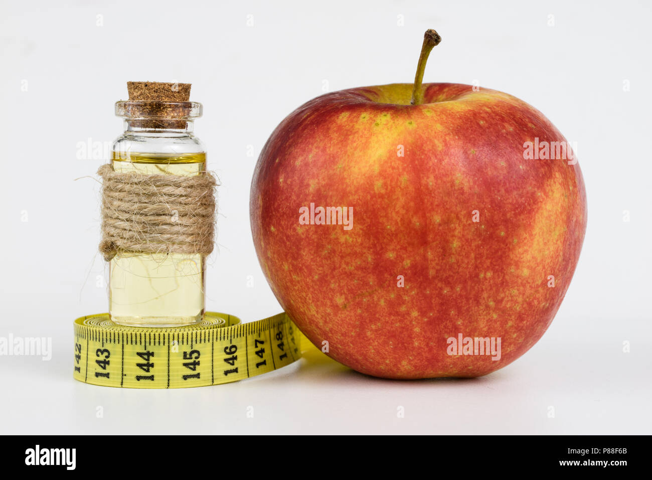 Red apples and a measure of tailor on a white table. Ripe fruits and a ...