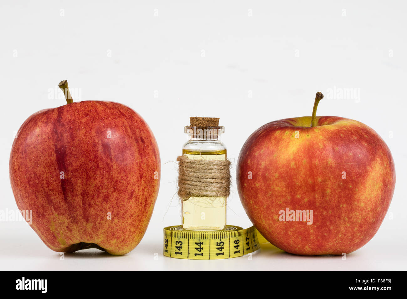 Red apples and a measure of tailor on a white table. Ripe fruits and a ...