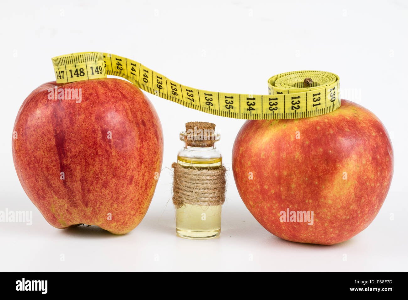 Red apples and a measure of tailor on a white table. Ripe fruits and a ...