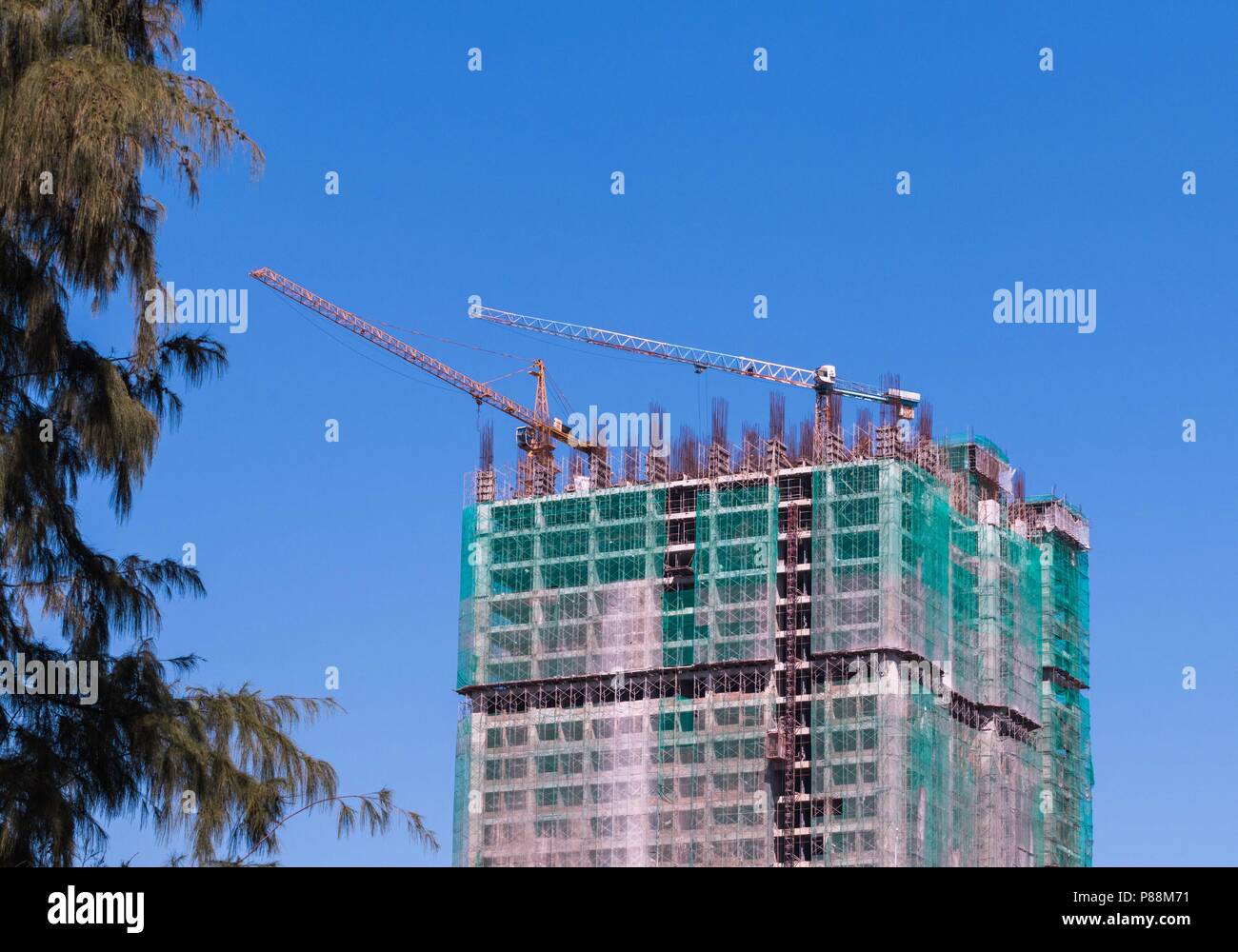 Building under construction, blue sky and tree Stock Photo - Alamy
