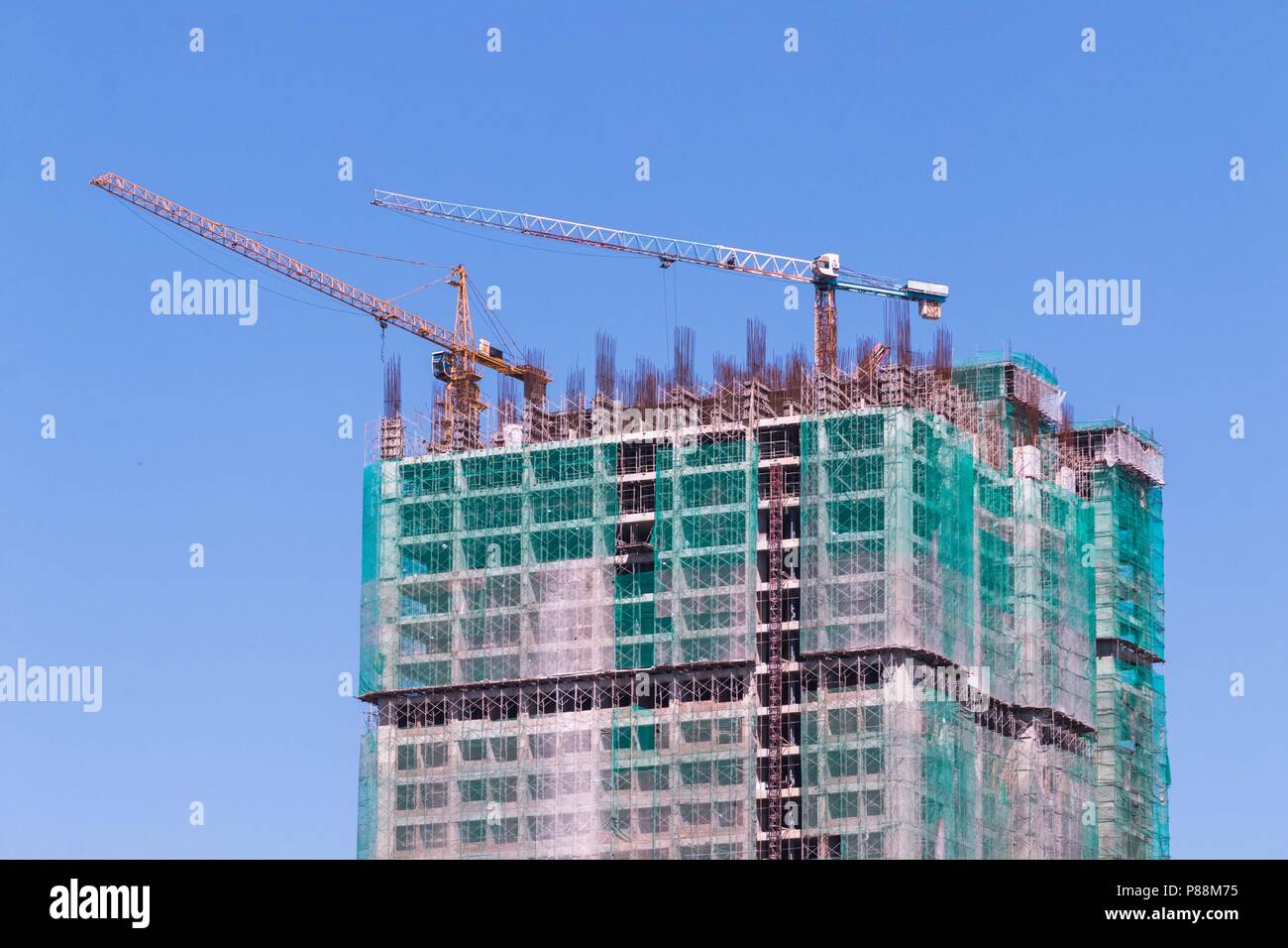 Building under construction, blue sky, big skyscraper Stock Photo - Alamy