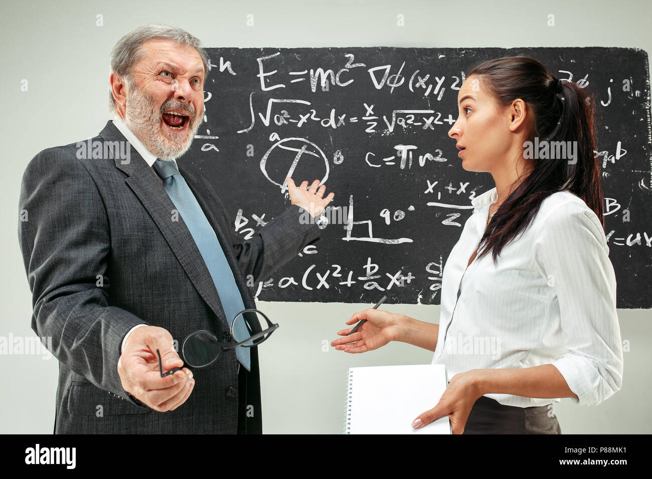 Male professor and young woman against chalkboard in classroom Stock ...
