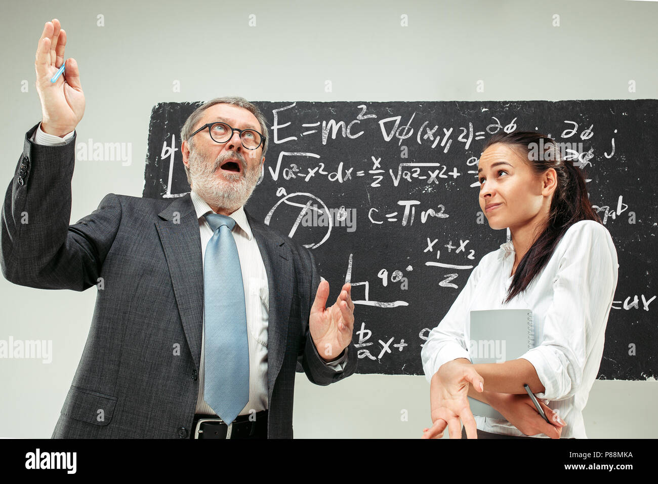 Male professor and young woman against chalkboard in classroom Stock ...
