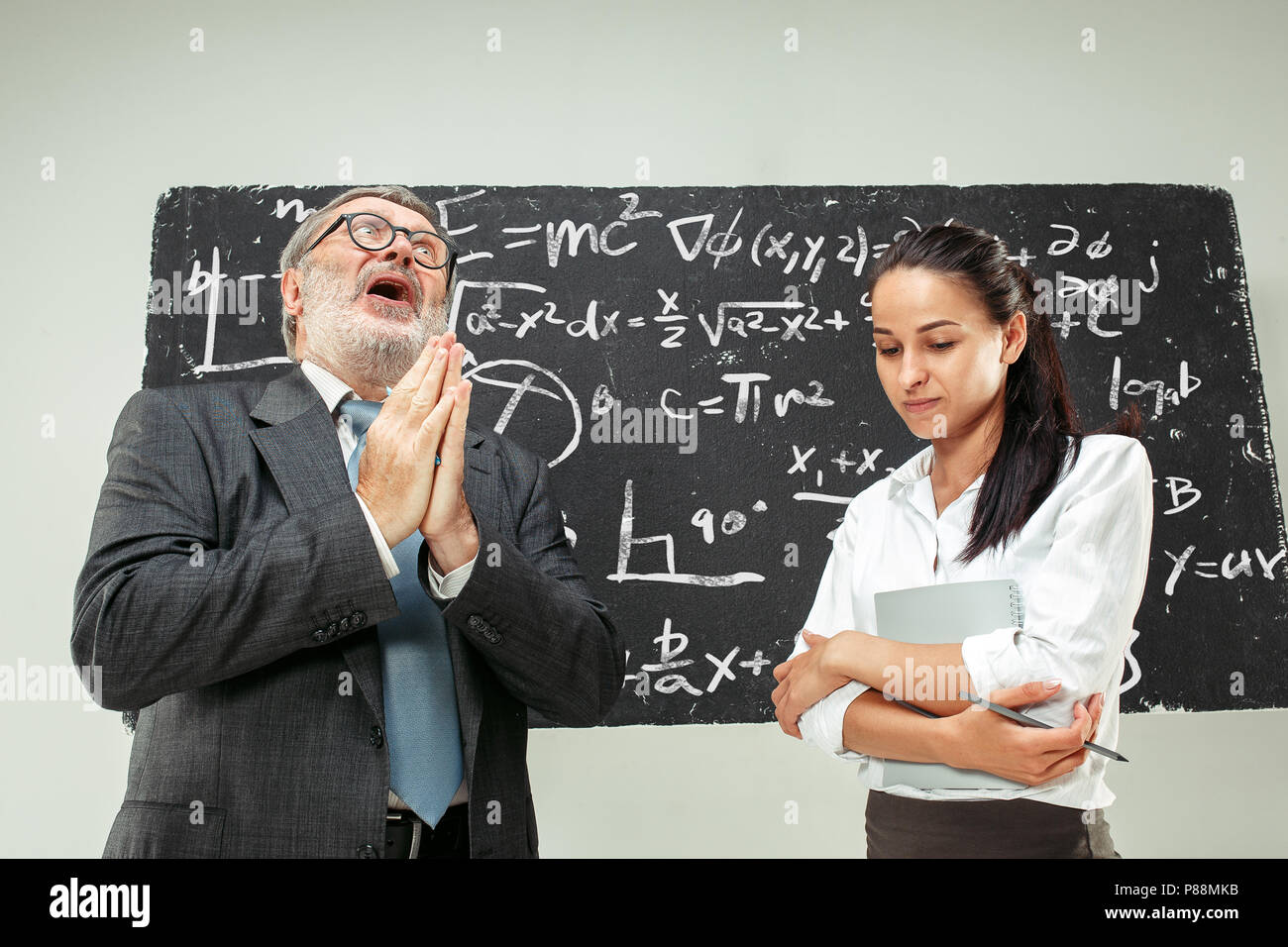 Male professor and young woman against chalkboard in classroom Stock ...
