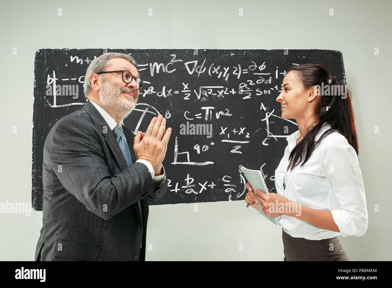 Male professor and young woman against chalkboard in classroom Stock ...