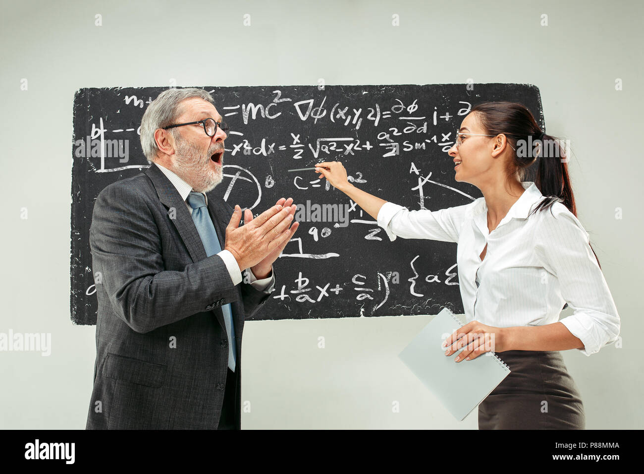 Male professor and young woman against chalkboard in classroom Stock ...