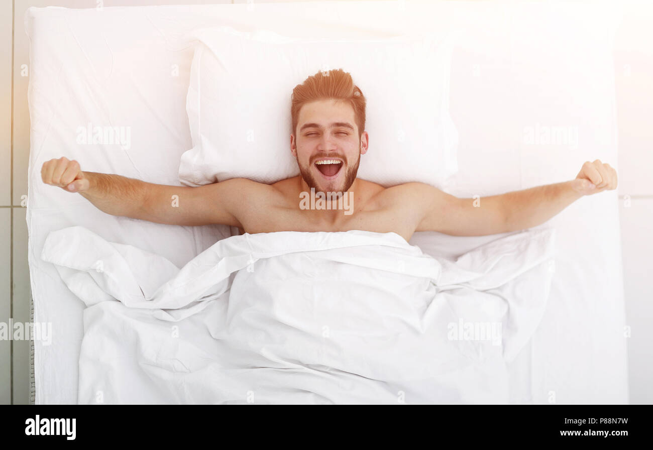 top view. happy man waking up in a comfortable bed Stock Photo - Alamy