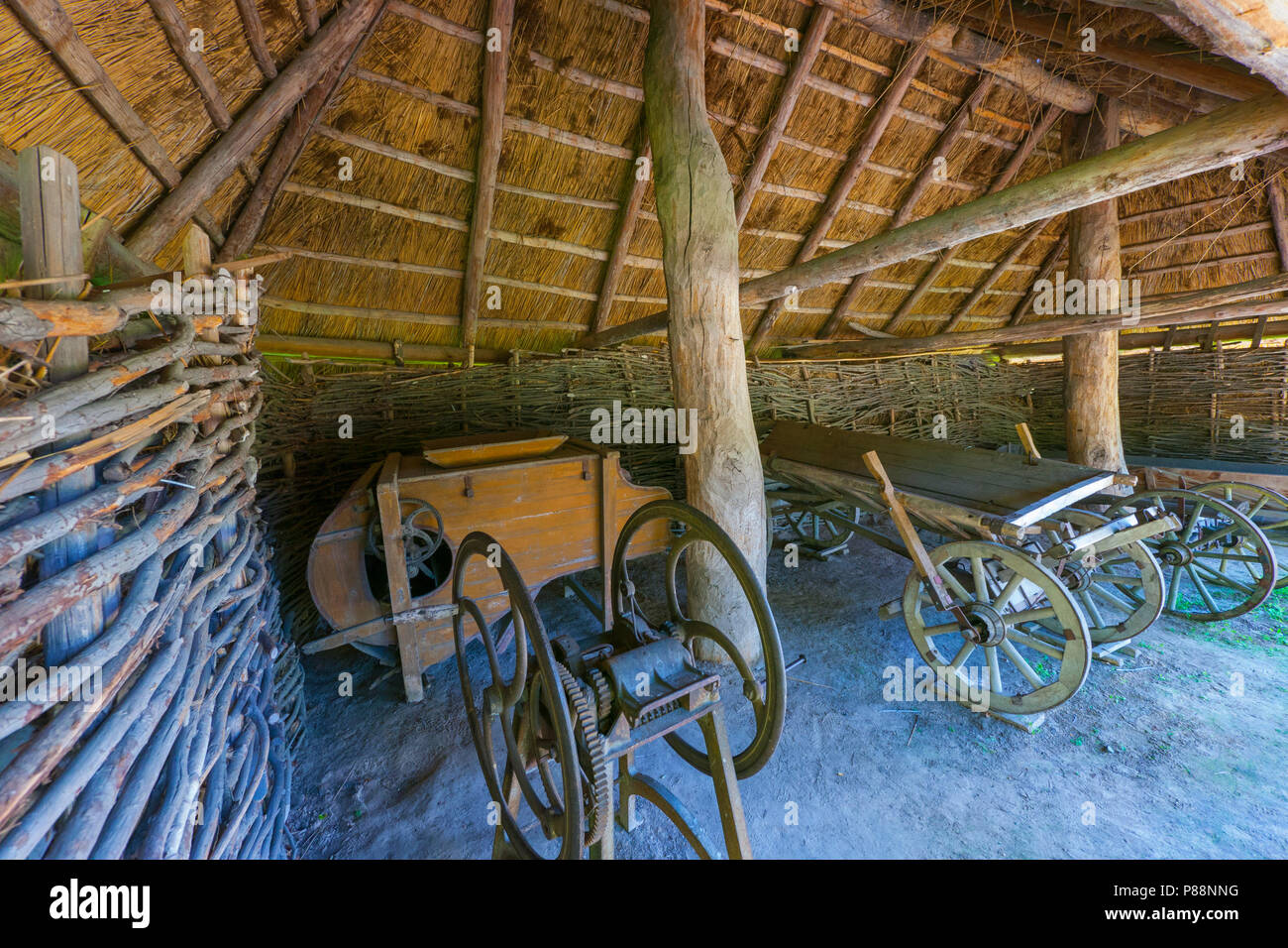 An ancient device for cutting grass, a cart with wooden wheels and an ...