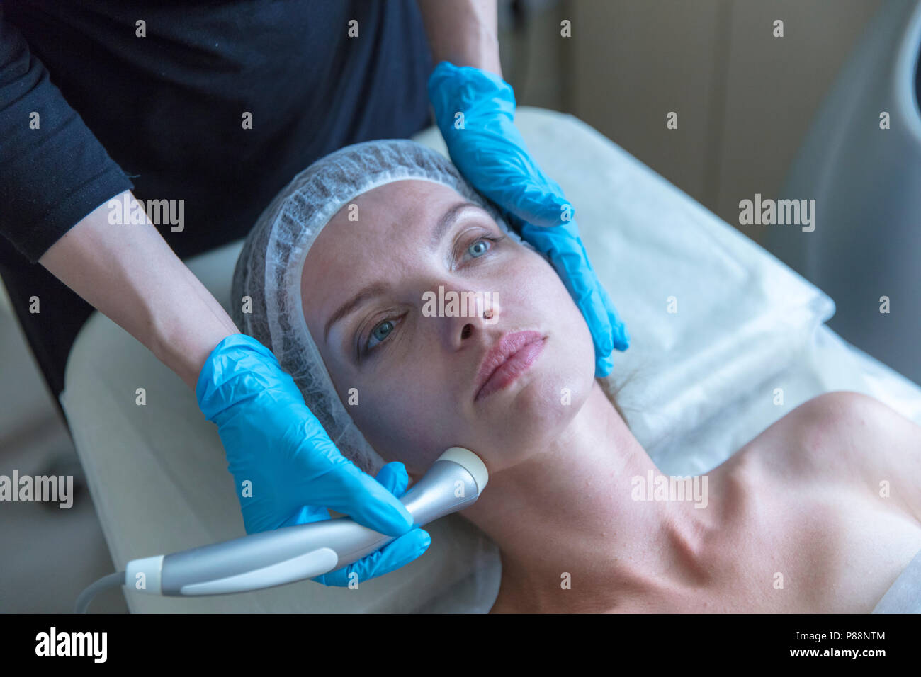 Beautiful woman in professional beauty salon during photo rejuvenation ...