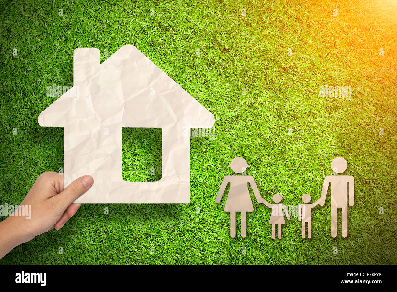 Hand hold House and family concept on green grass background, property ...