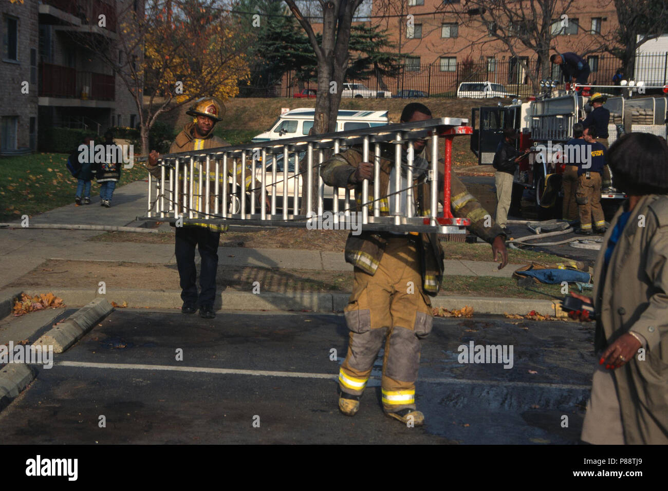 firefighters carrying a ladder Stock Photo - Alamy