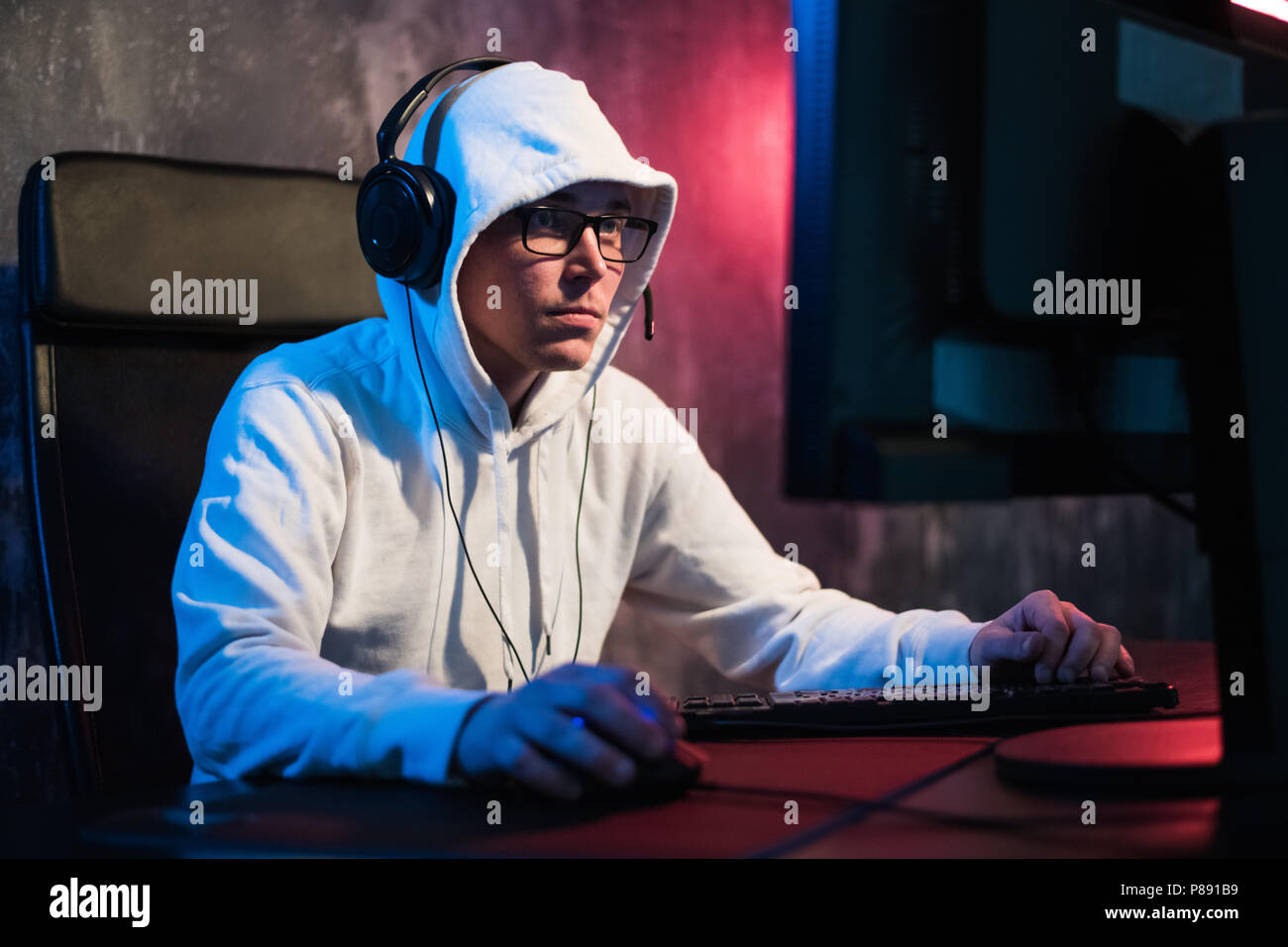 male hooded gamer playing online game on pc computer Stock Photo - Alamy
