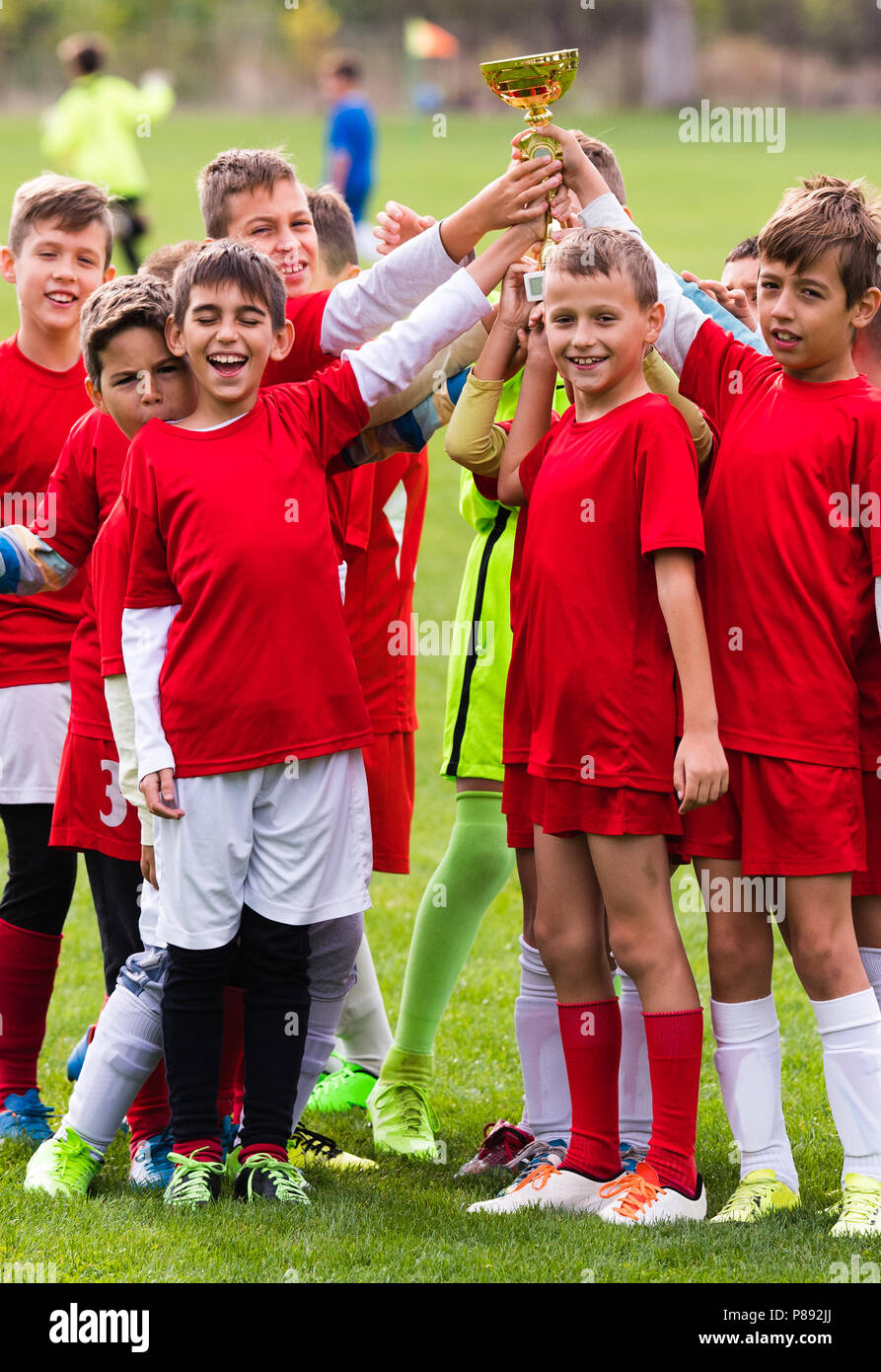 Kids soccer football - young children players celebrating with a trophy ...